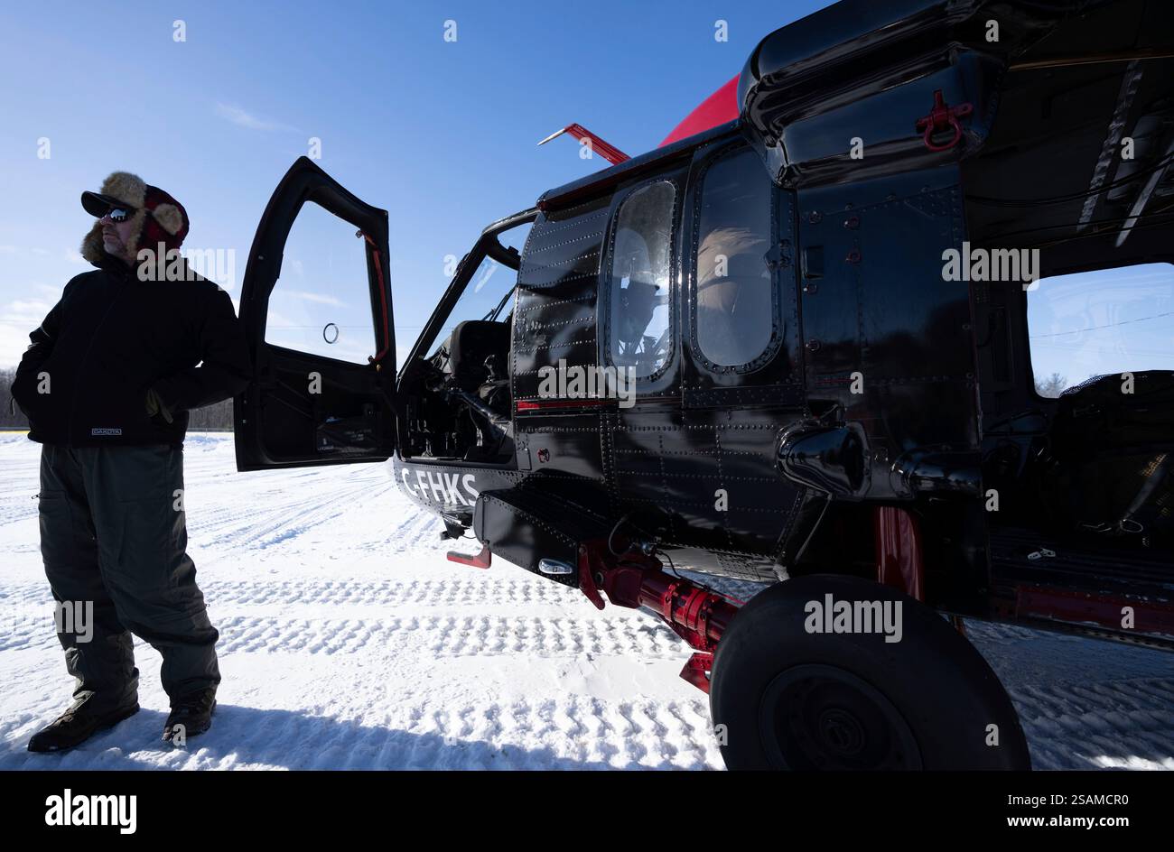 A pilot stands outside the new Black Hawk helicopter acquired by the ...