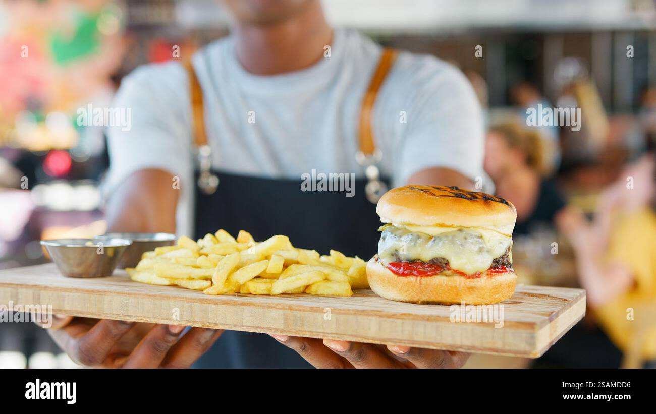 Close Up Of Male Server With Burger And Fries In Busy Bar Restaurant ...
