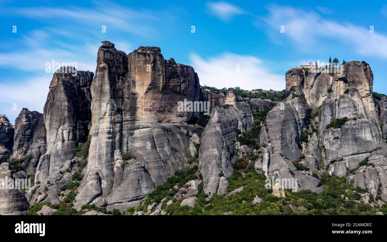 A stunning view of towering rock formations under a blue sky with wispy ...