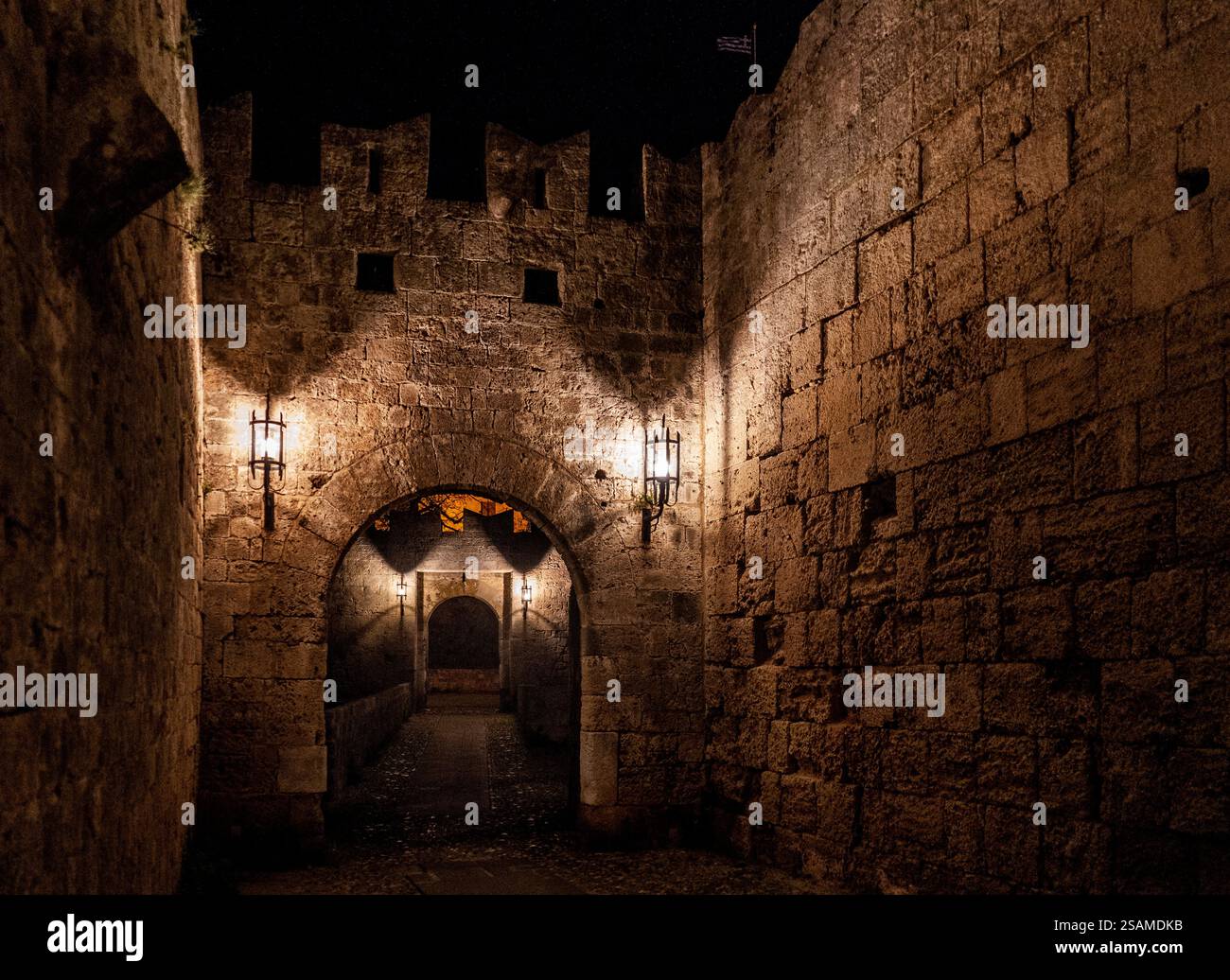 A dimly lit stone pathway leading through an ancient archway, flanked ...