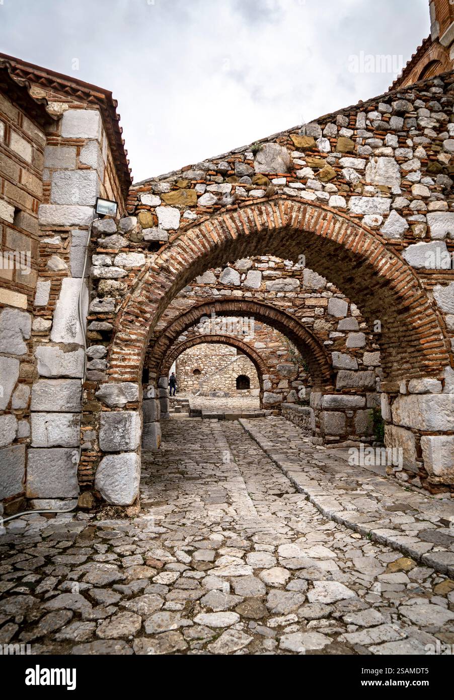A picturesque stone pathway lined with ancient arches, leading through ...