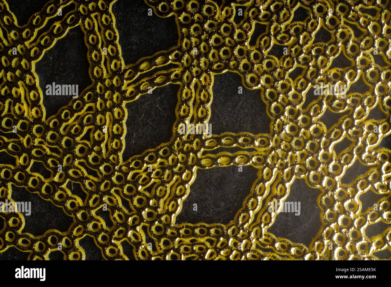 Intricate golden network design on dark textured surface showcases ...