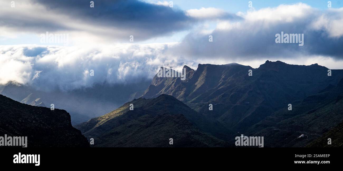 A breathtaking view of rugged mountains under a cloudy sky, showcasing ...