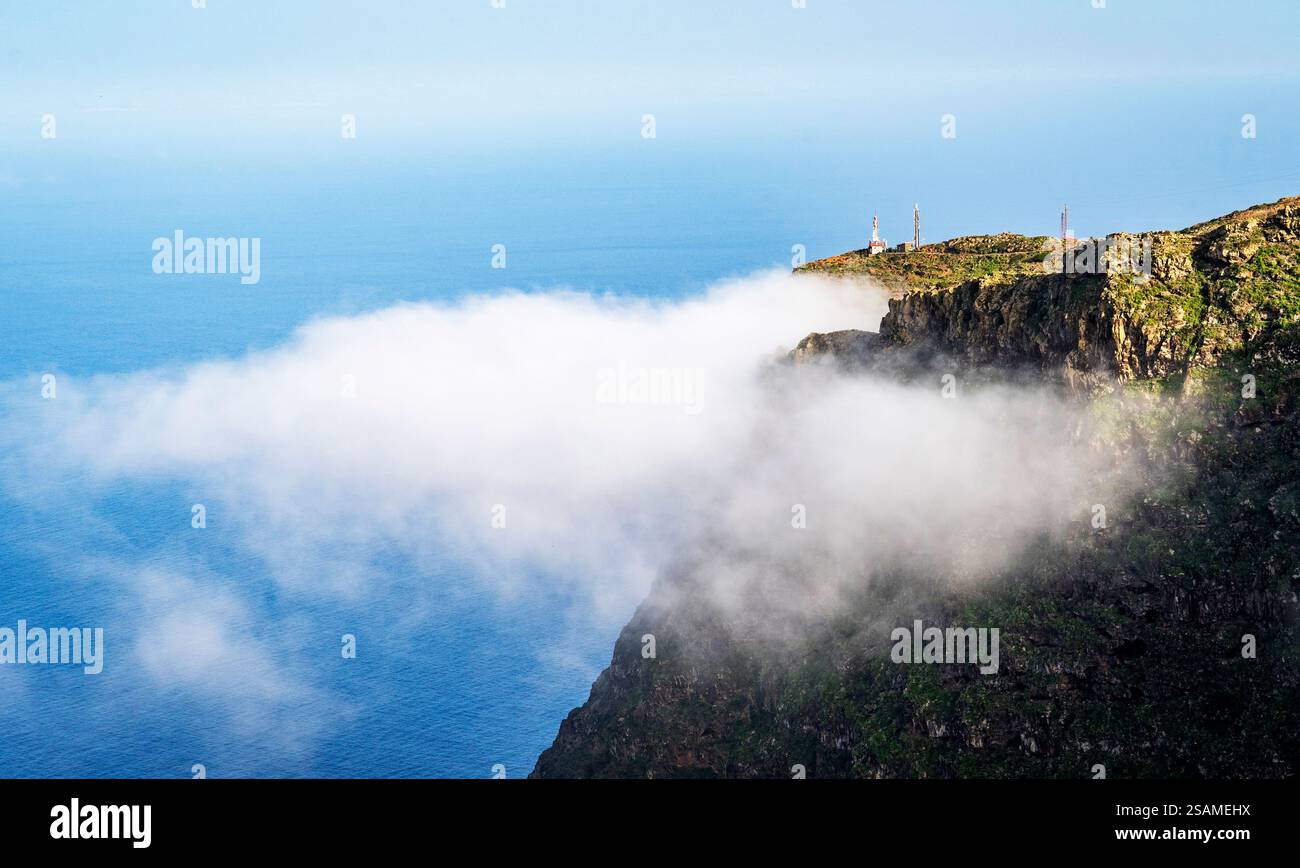 A scenic view of a cliff overlooking the ocean, with fog rolling over ...