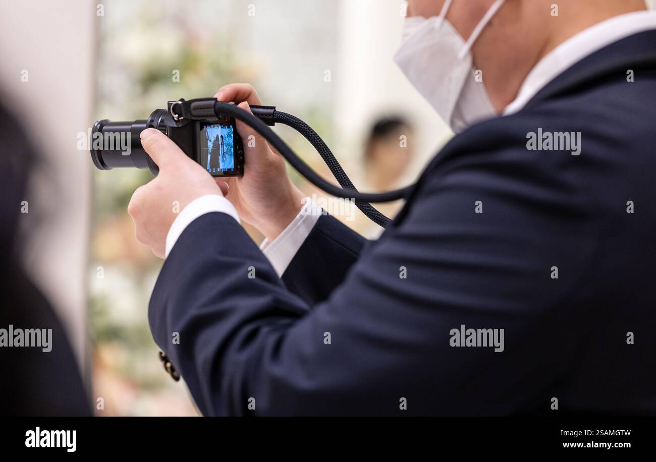 Man wearing a mask and holding a camera. The camera is attached to a ...
