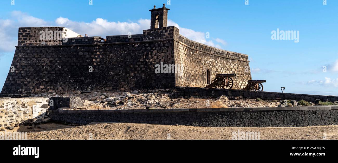 A historic stone fortress with cannons, set against a blue sky. The ...