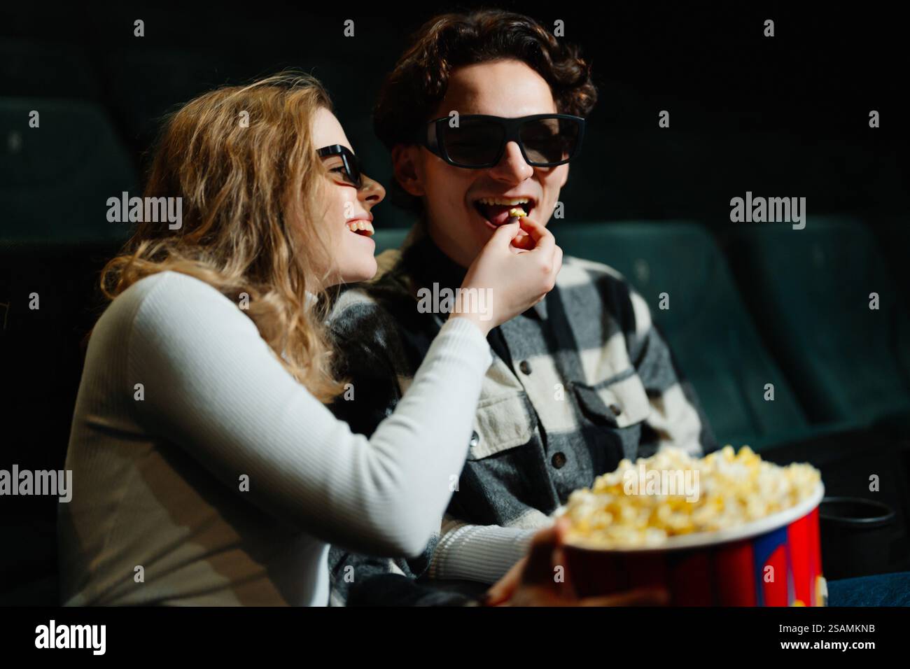 Young couple enjoying popcorn together in a movie theater Stock Photo ...
