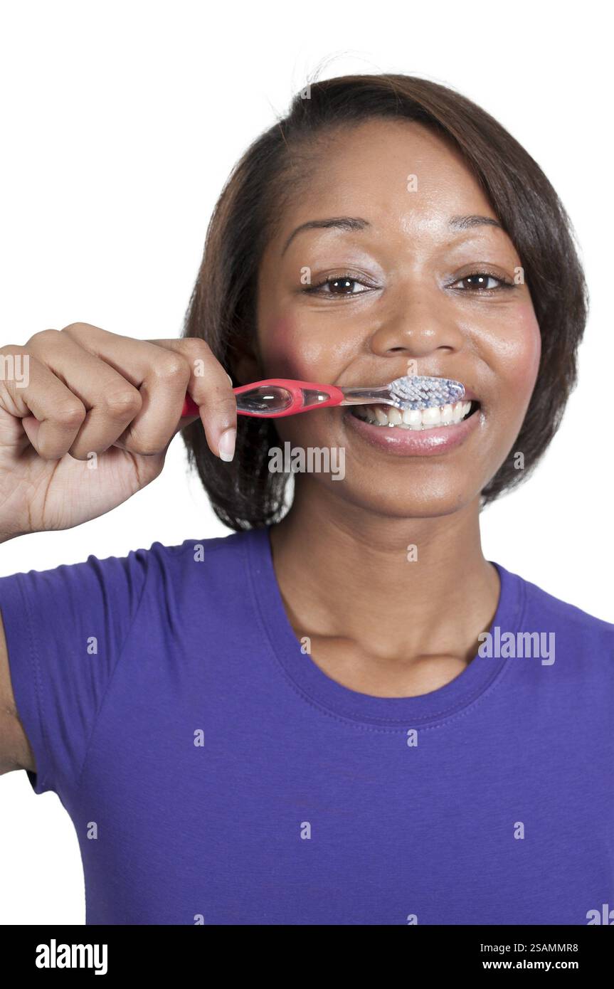 A beautiful black woman practicing good oral dental care by brushing ...