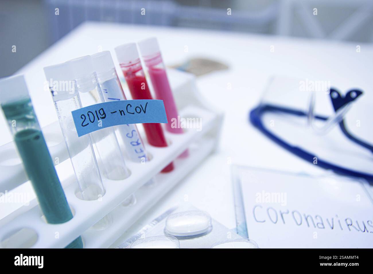 Test tubes and a blue label '2019-nCoV' on a desk with medical items ...