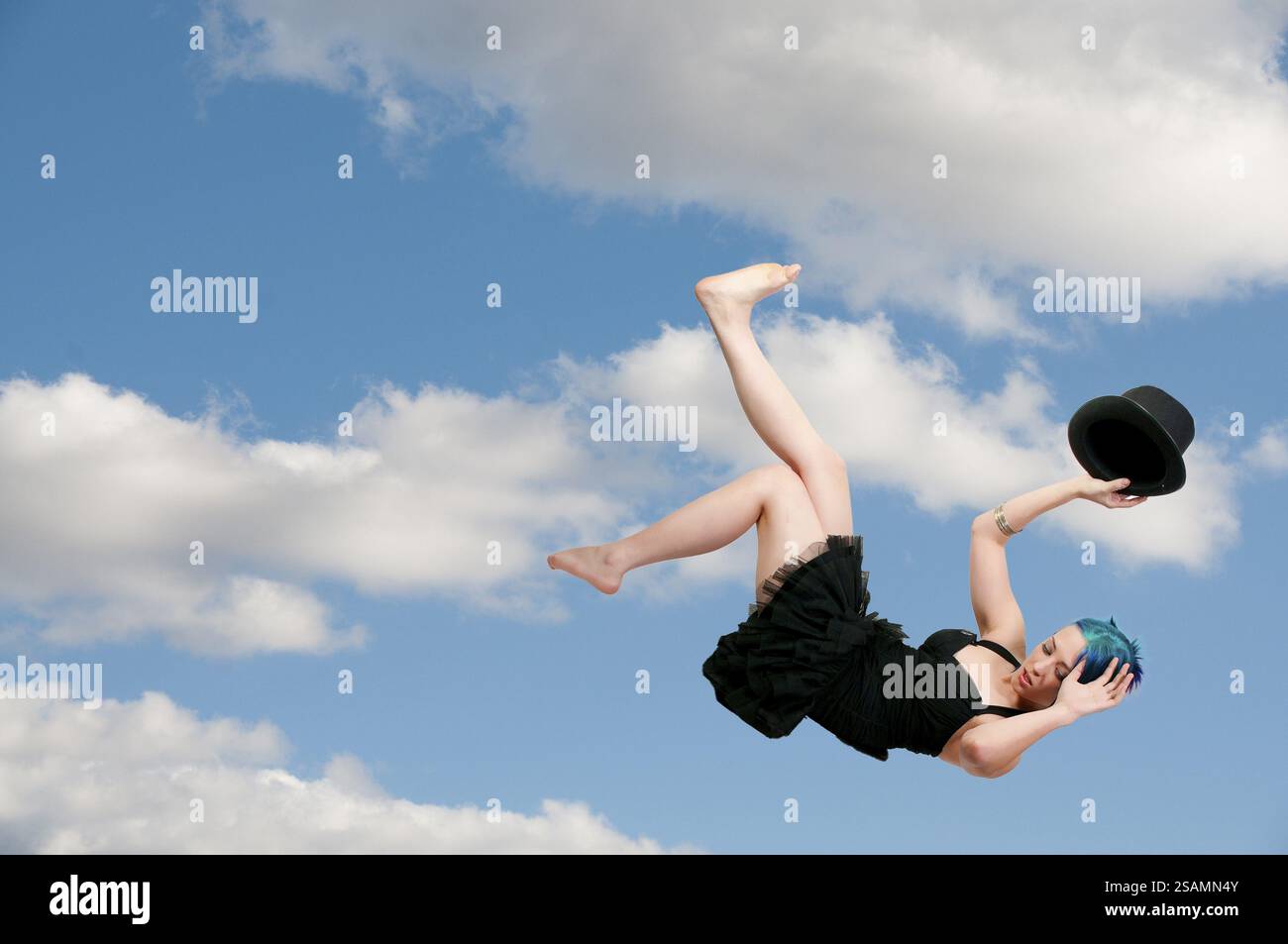 A beautiful young actress dancer wearing a top hat flying through the ...