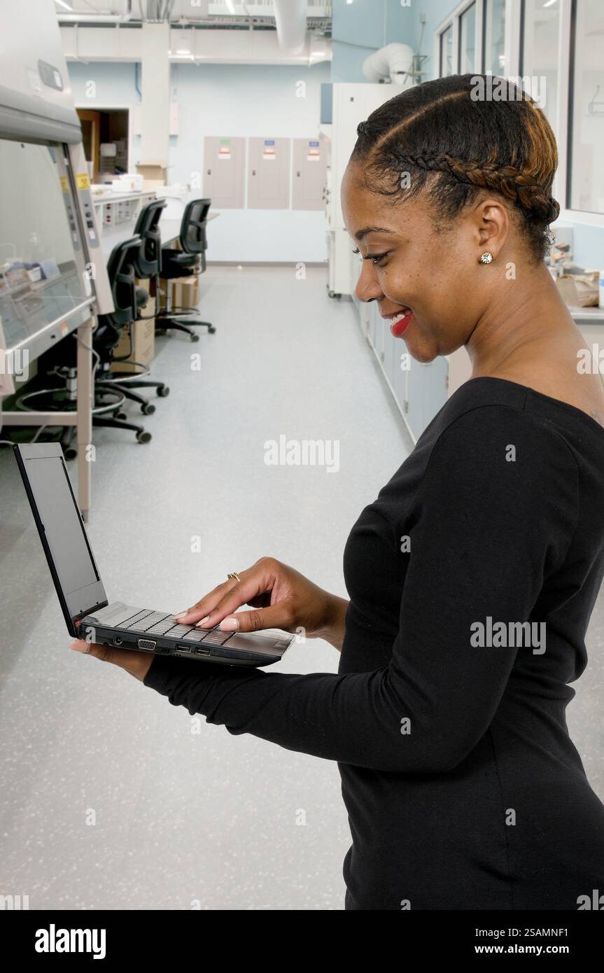 Beautiful computer savvy young black woman using a laptop Stock Photo ...