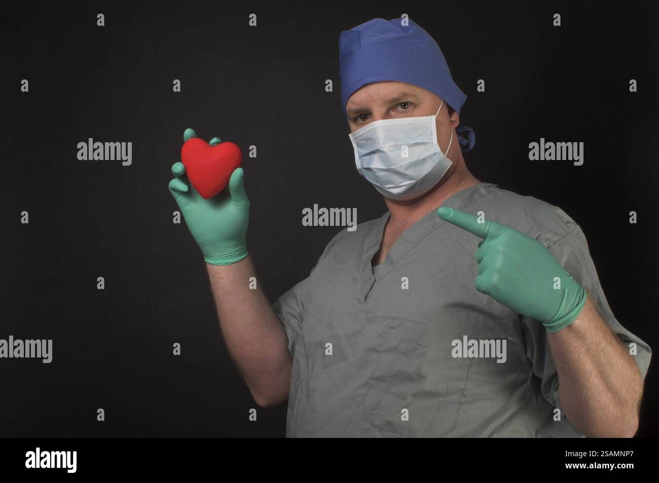 A cardiologist holding a patients heart in his hand Stock Photo - Alamy