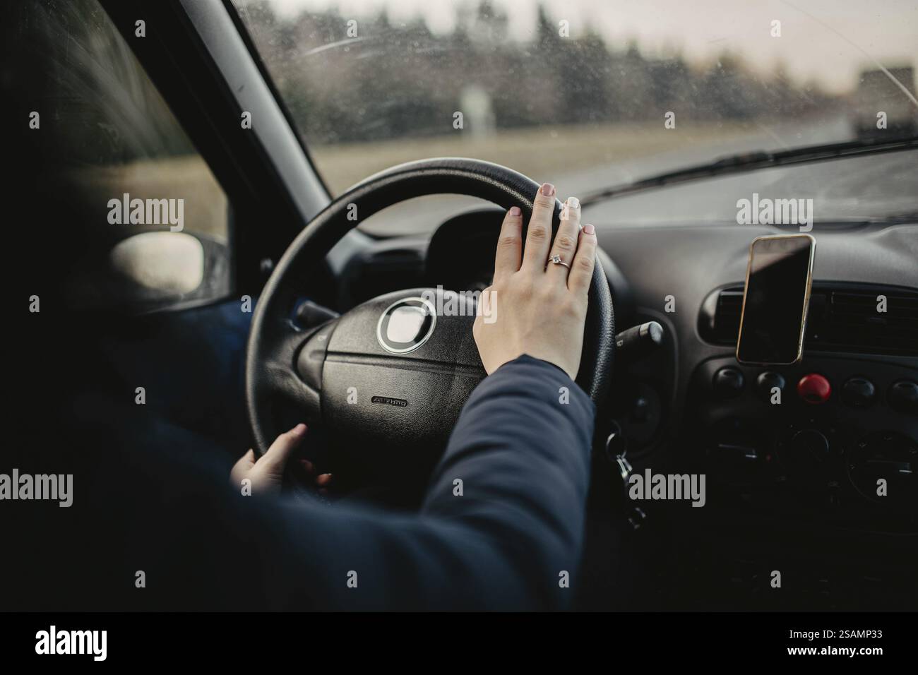 A hand on a steering wheel with nature scenery outside the window Stock ...