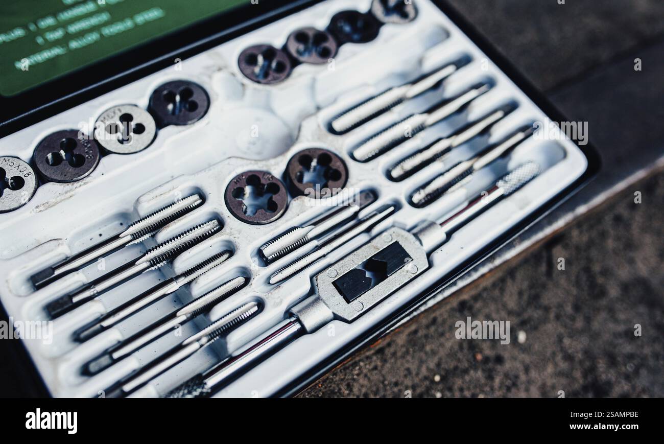Close-up of a tap and die set with various sizes, organized neatly in a ...