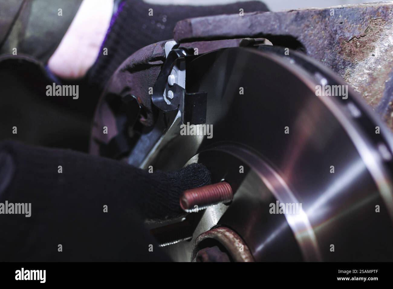 Mechanic working on brake installation with gloved hands Stock Photo ...
