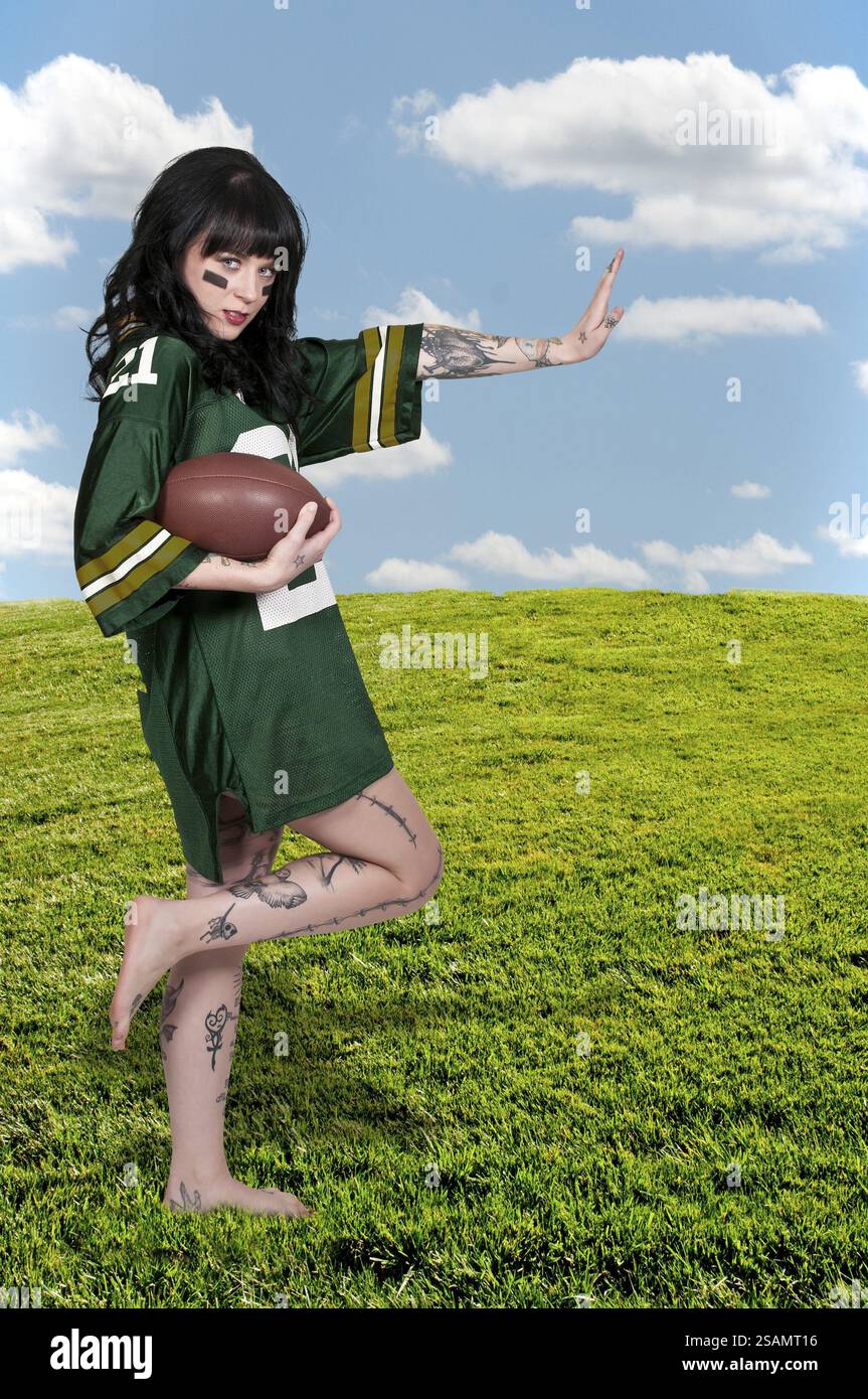 Beautiful young woman playing a game of football Stock Photo - Alamy