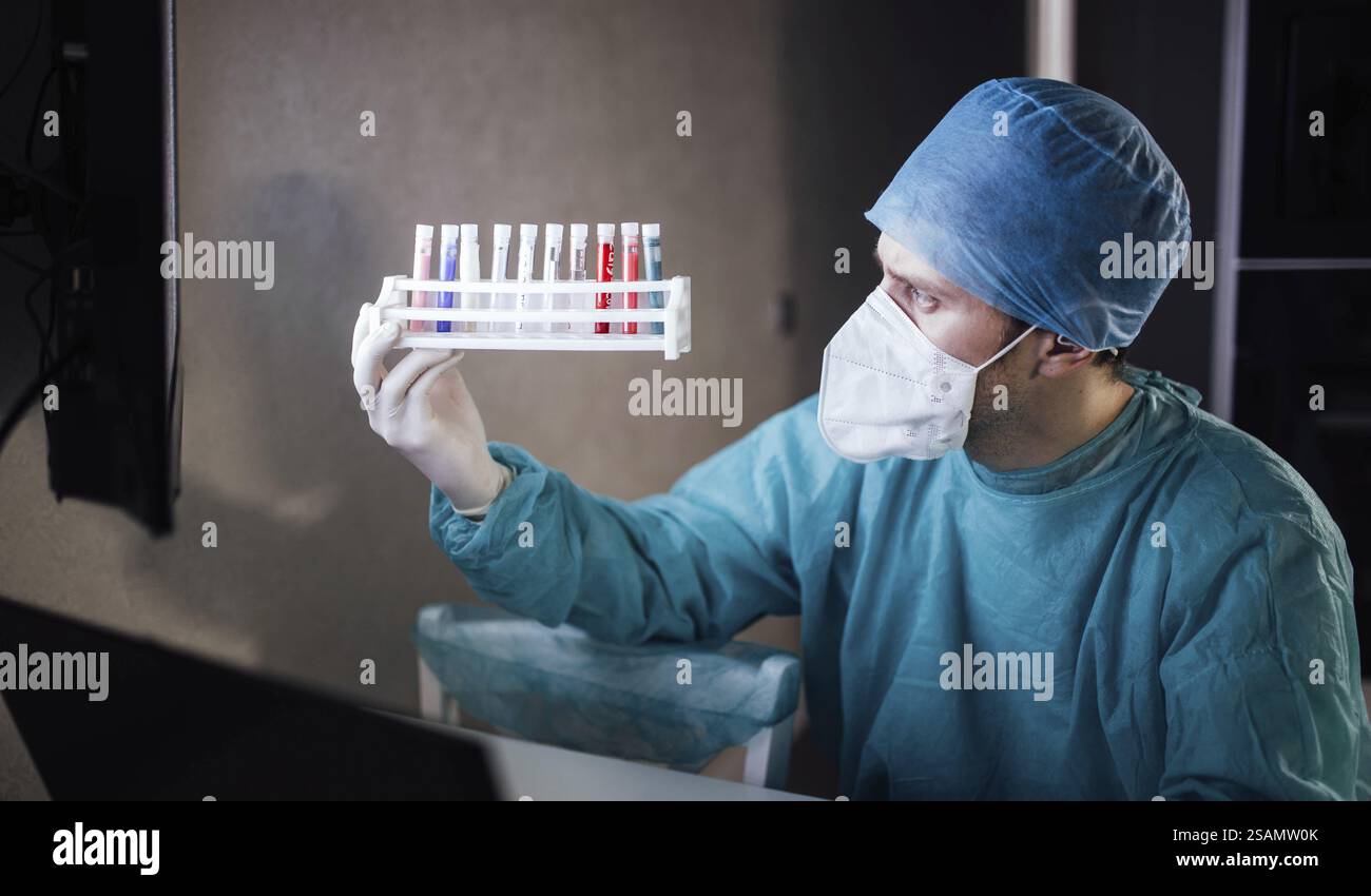 Medical professional holding a rack of test tubes under examination ...
