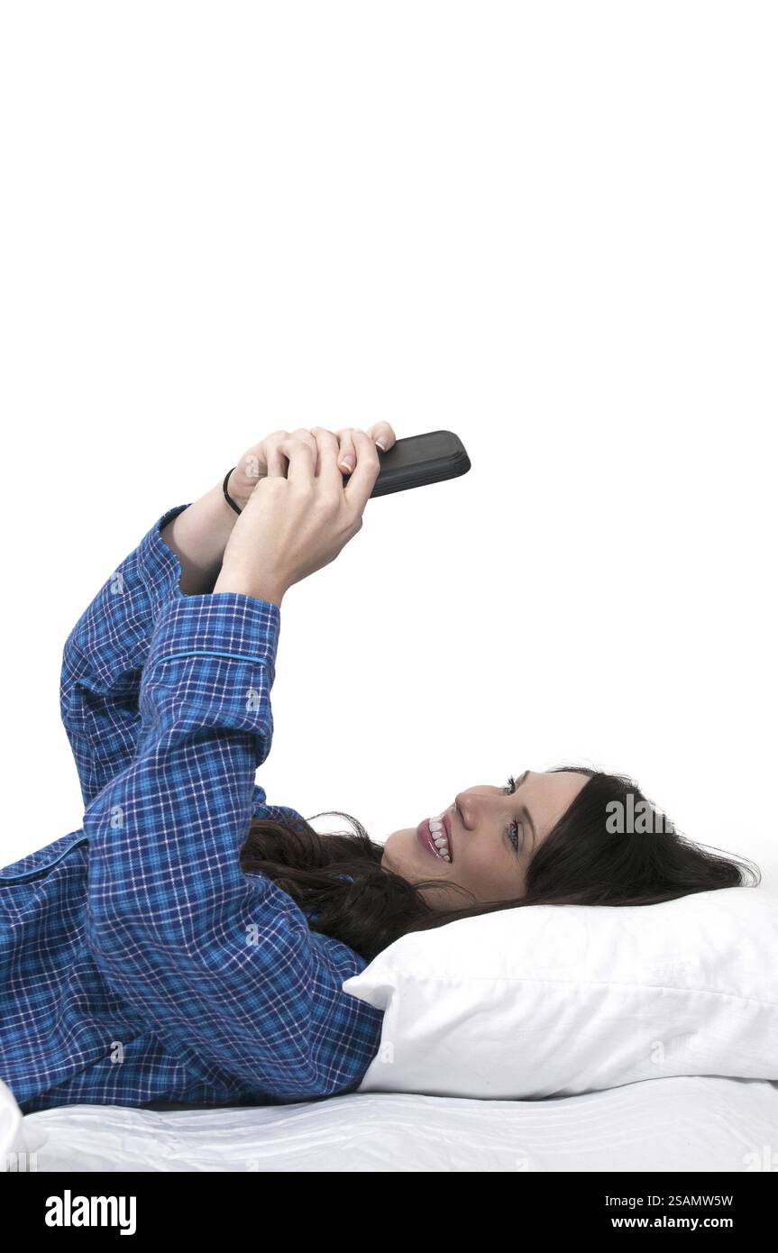 Beautiful young woman texting in bed on her mobile phone Stock Photo ...