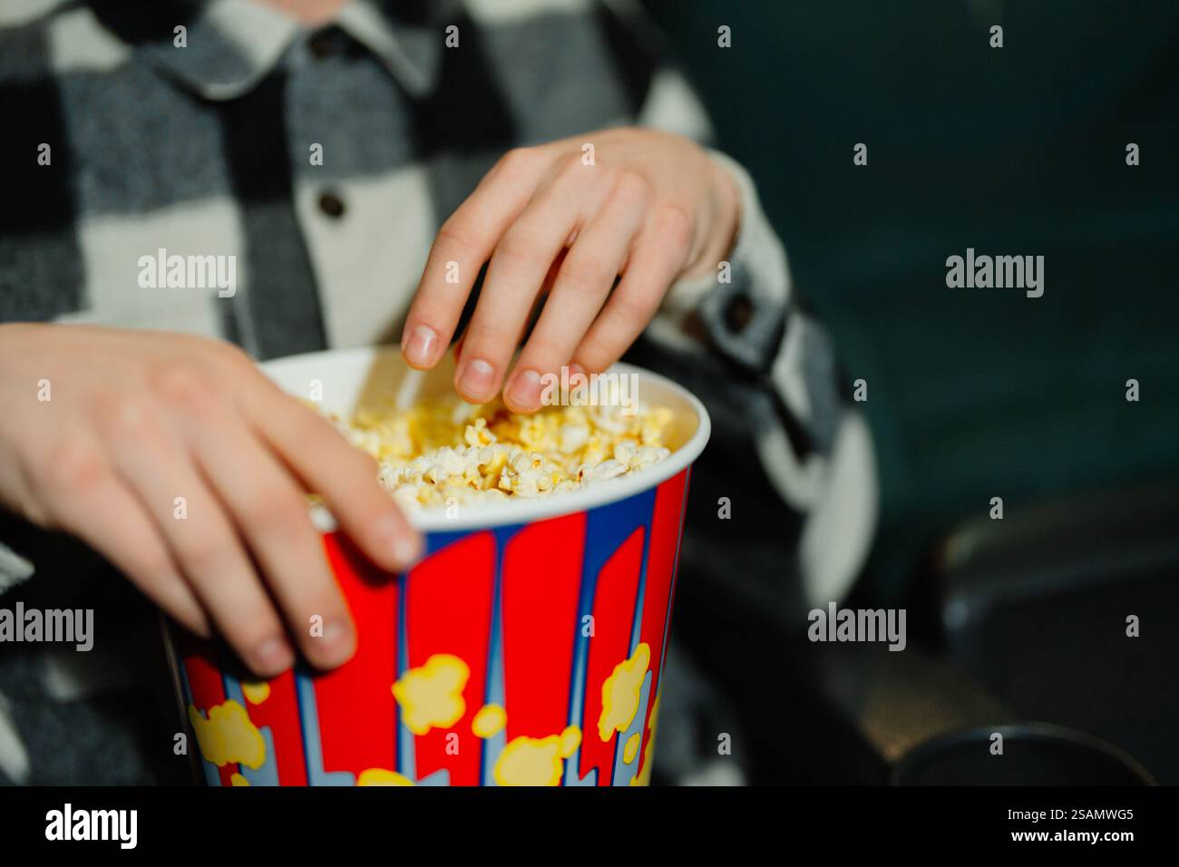 Enjoying popcorn during a movie theater experience at night with ...