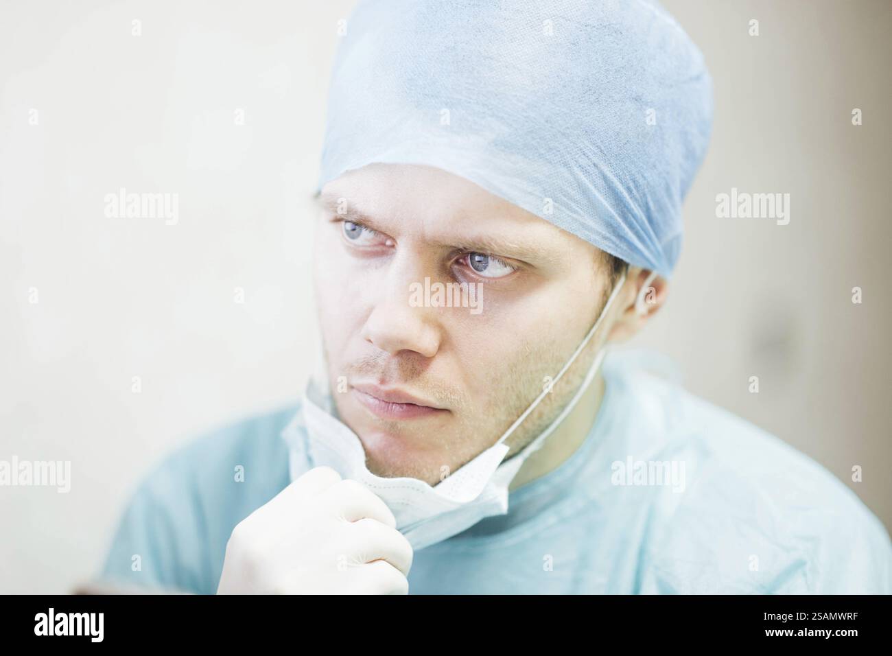 Scientist in lab with mask pulled down, appearing thoughtful and ...