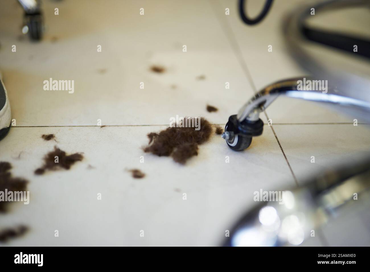 Hair clippings scattered on the floor near a salon chair during a ...