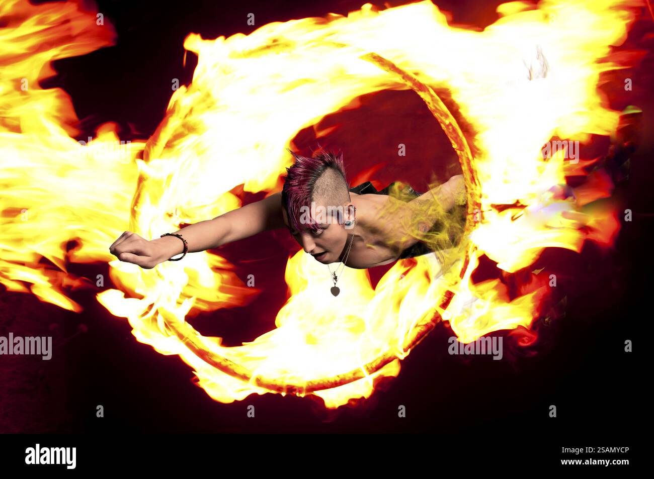 Beautiful woman jumping through a ring of fire Stock Photo - Alamy