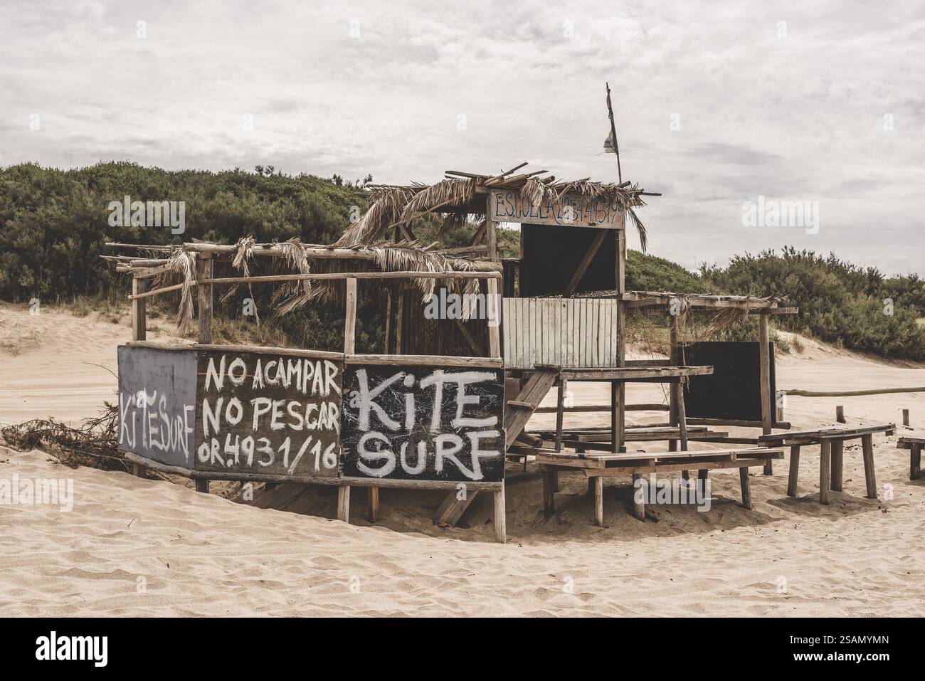 Charming beach hut with kite surfing signage nestled among the dunes ...
