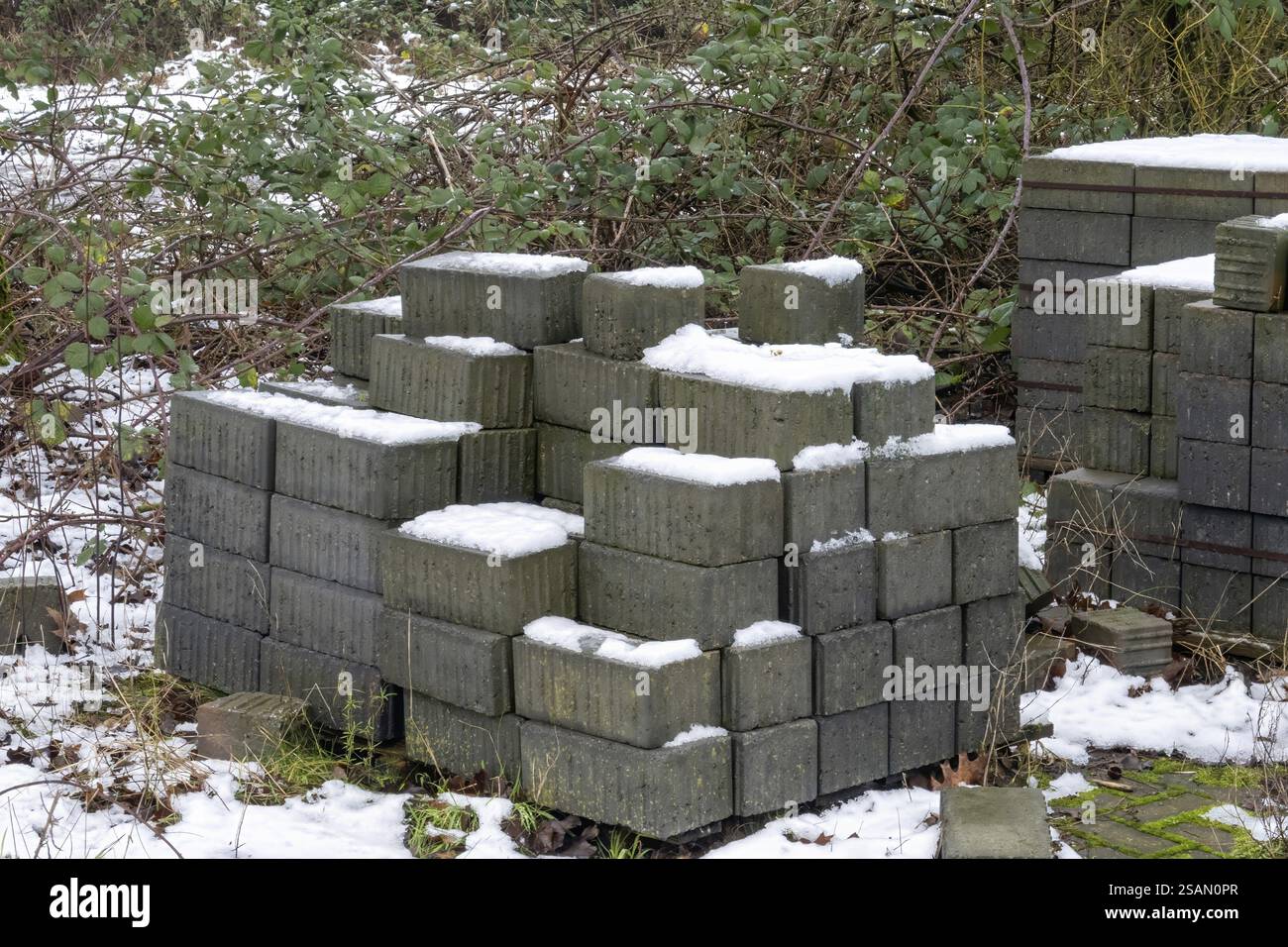 Grey concrete bricks laying on each other covered with snow during ...