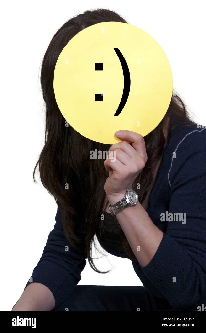 A beautiful depressed young woman hiding behind a smiley face Stock ...