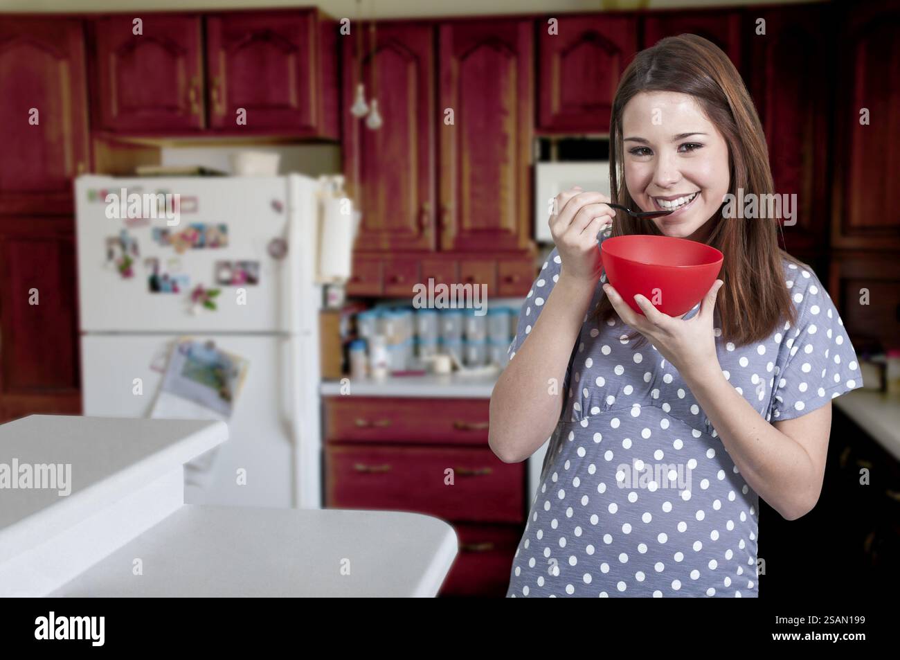 A beautiful woman eating food from a bowl Stock Photo - Alamy