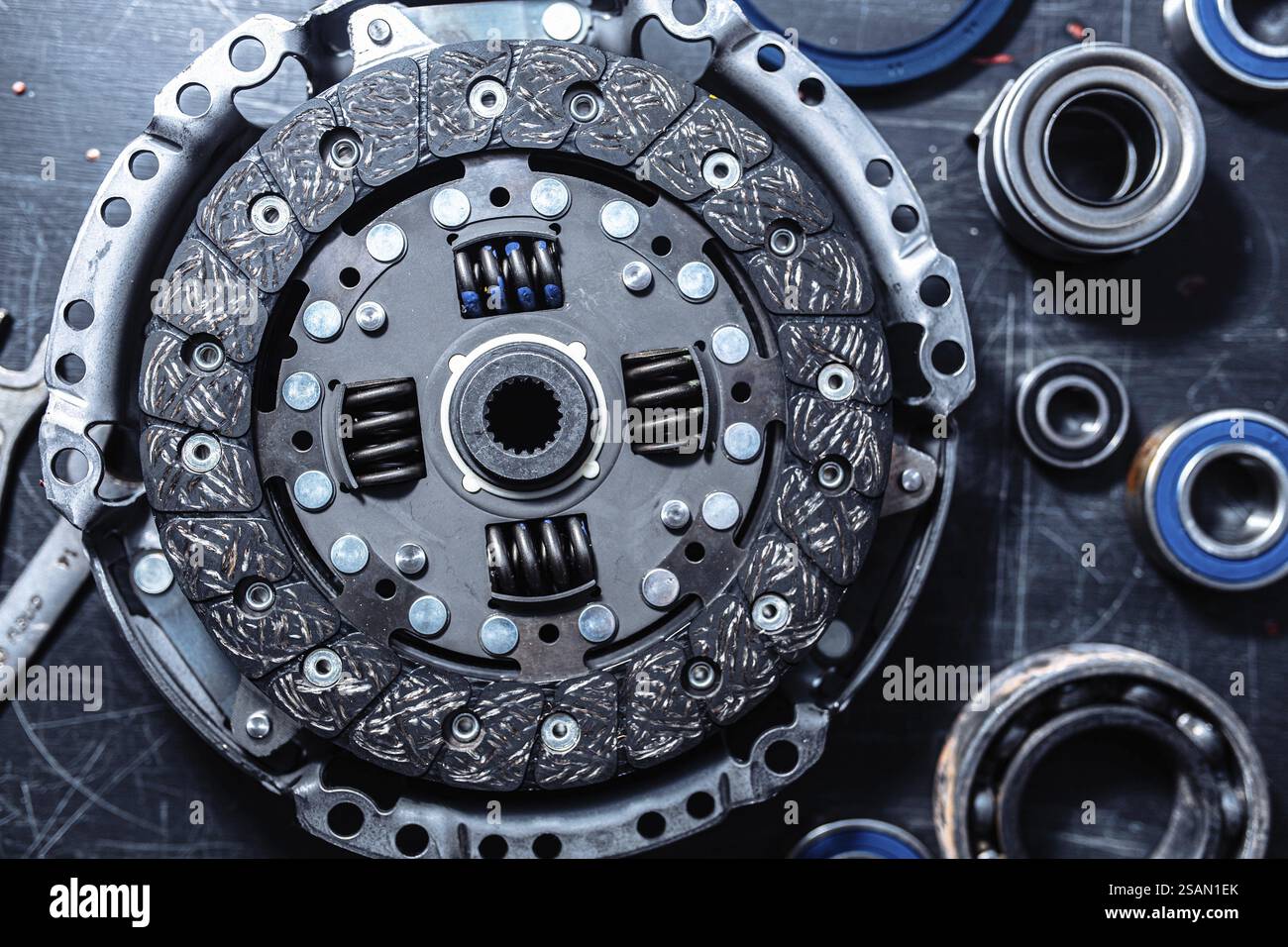 Close-up of a mechanical clutch and gears on a workbench in blue tones ...