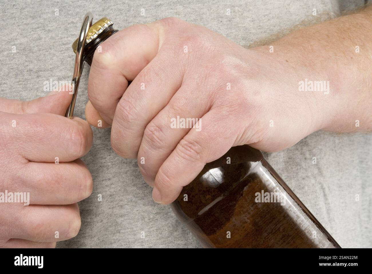 A person using a bottle opener to open a beer Stock Photo - Alamy