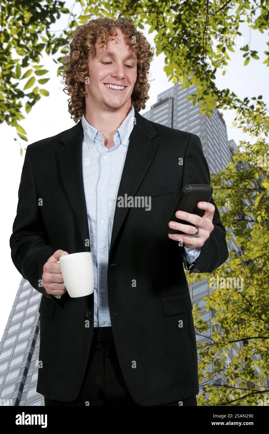 Handsome man using a cell phone for texting while drinking coffee Stock ...