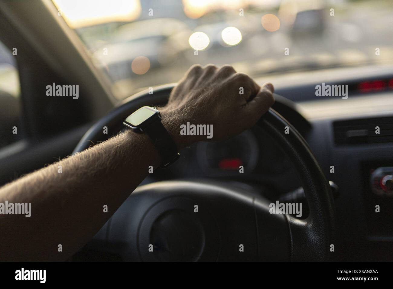 Hand on car steering wheel with watch, driving at sunset Stock Photo ...