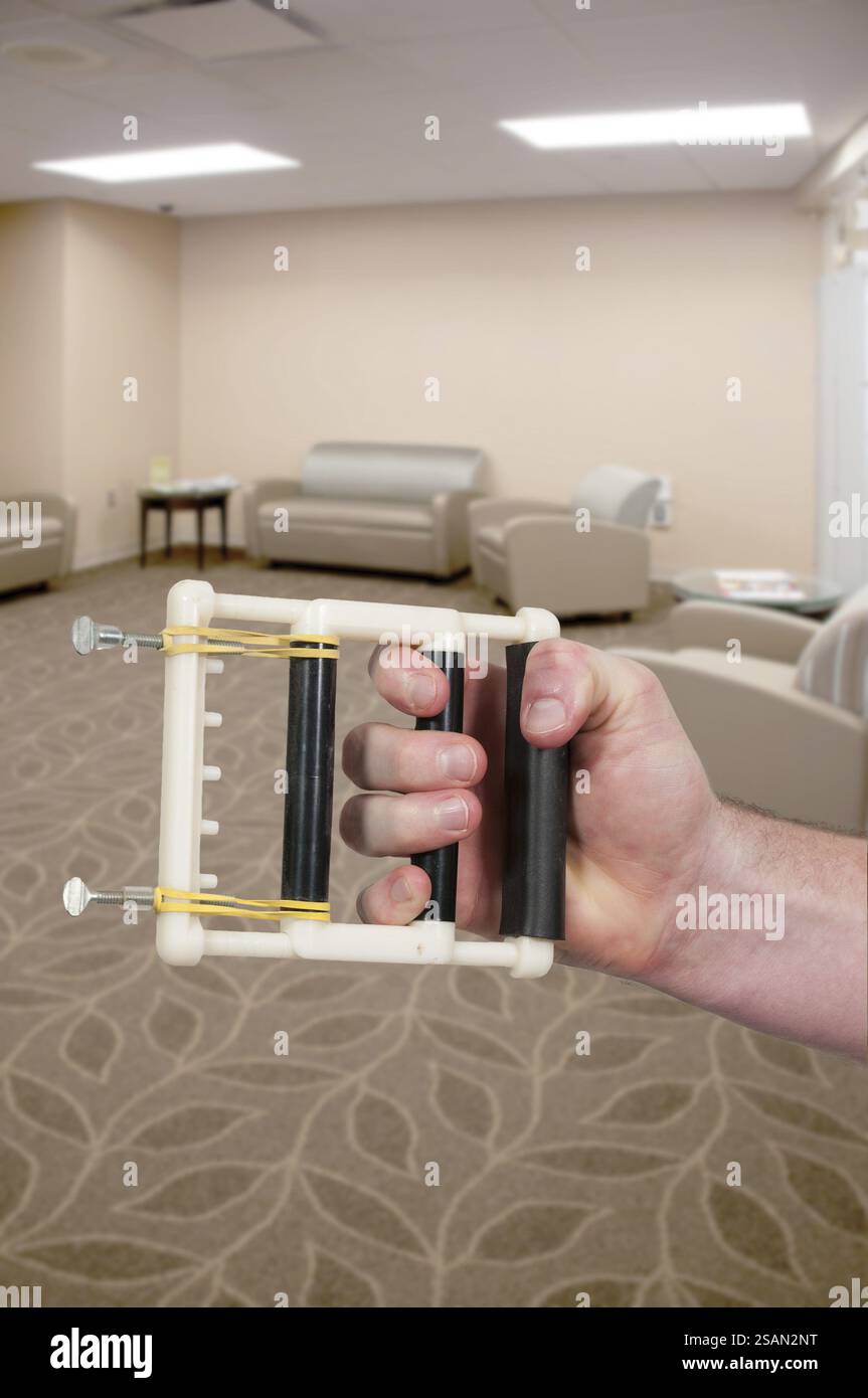 Man using a hand grip exerciser for strength Stock Photo - Alamy
