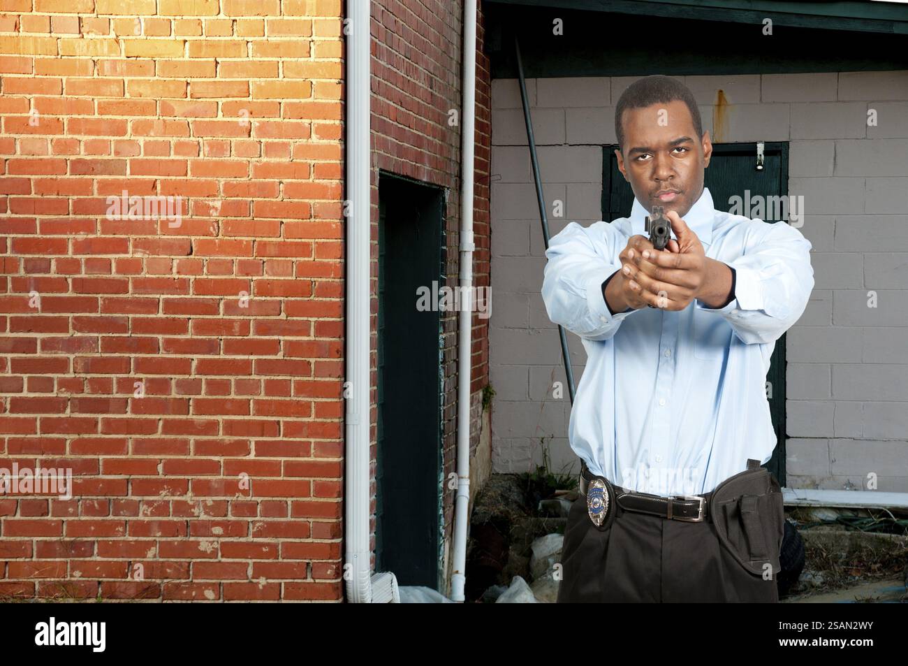 A black African American police detective man on the job with a gun ...