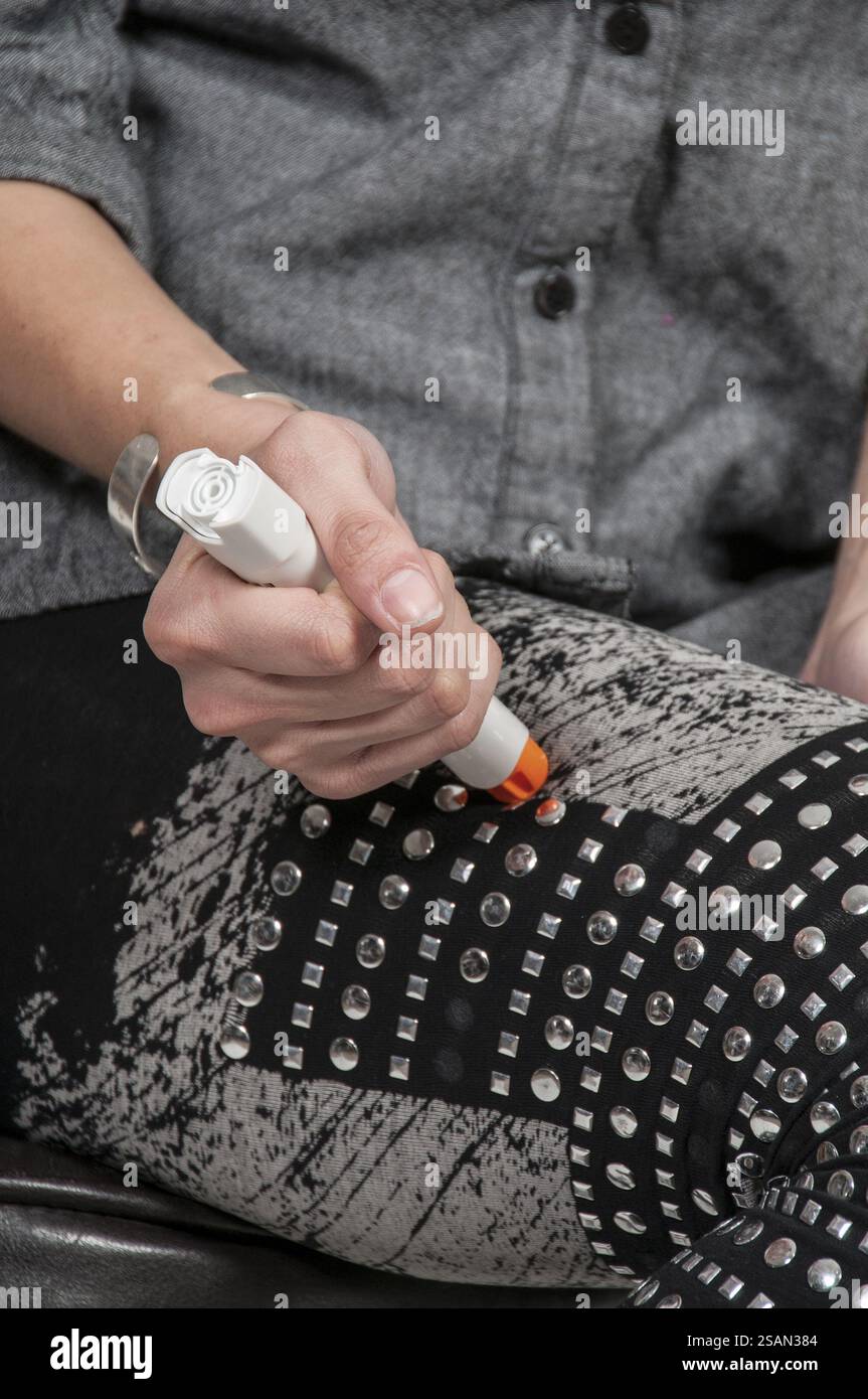 Woman injecting emergency medicine into her leg Stock Photo - Alamy