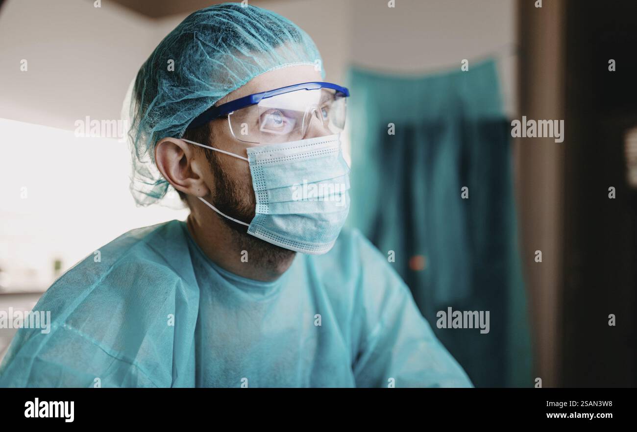 Doctor in mask looking focused and attentive in medical environment ...