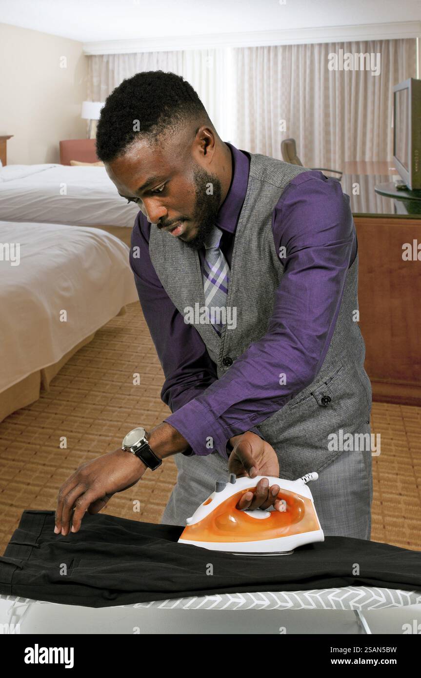 Handsome african american man with a clothes iron about to press his ...