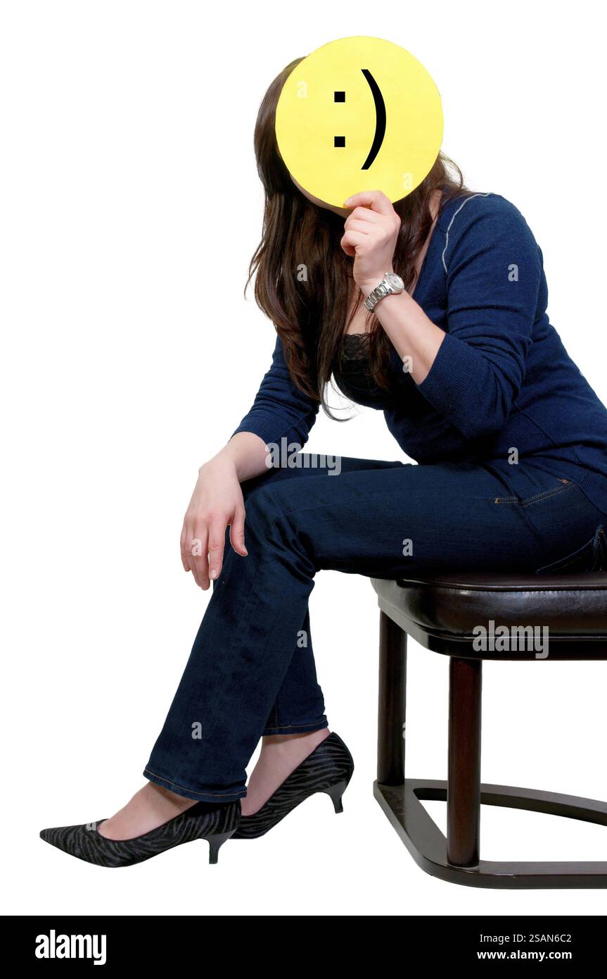 A beautiful depressed young woman hiding behind a smiley face Stock ...
