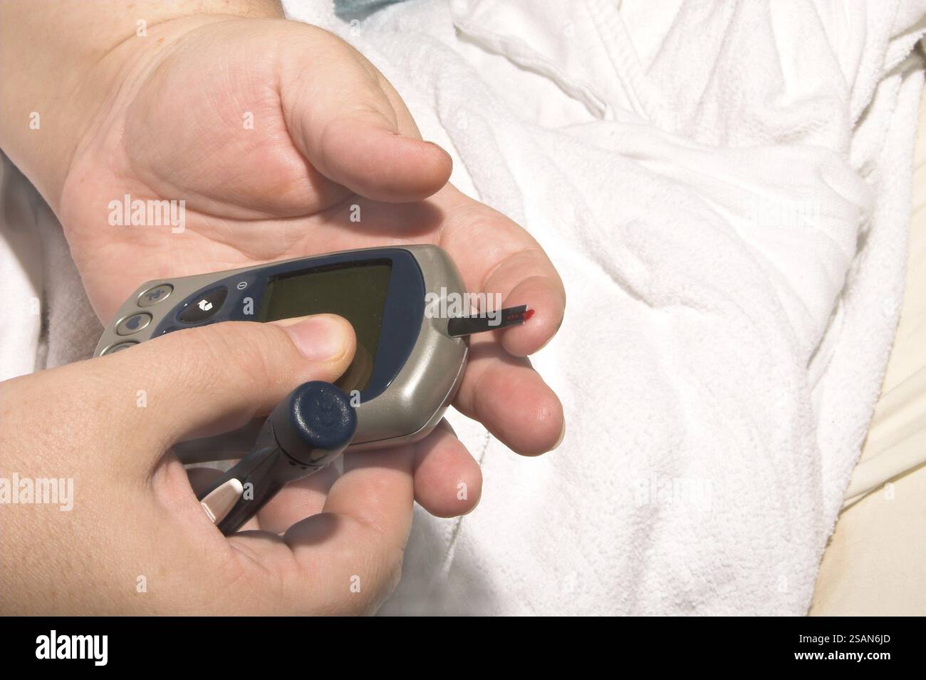 Using a glucometer to check blood sugar levels Stock Photo - Alamy