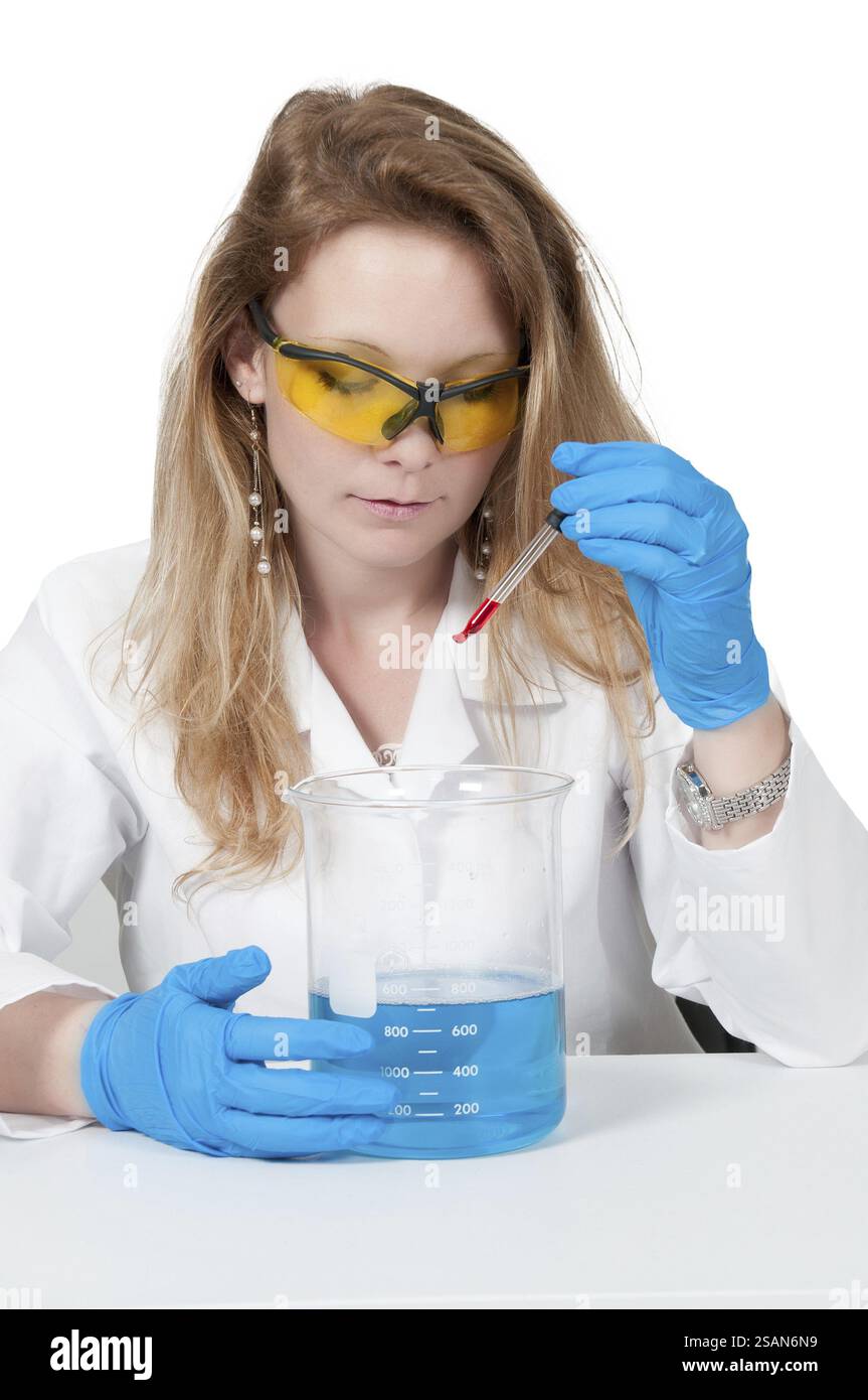 Beautiful woman scientist investigating a glass beaker Stock Photo - Alamy