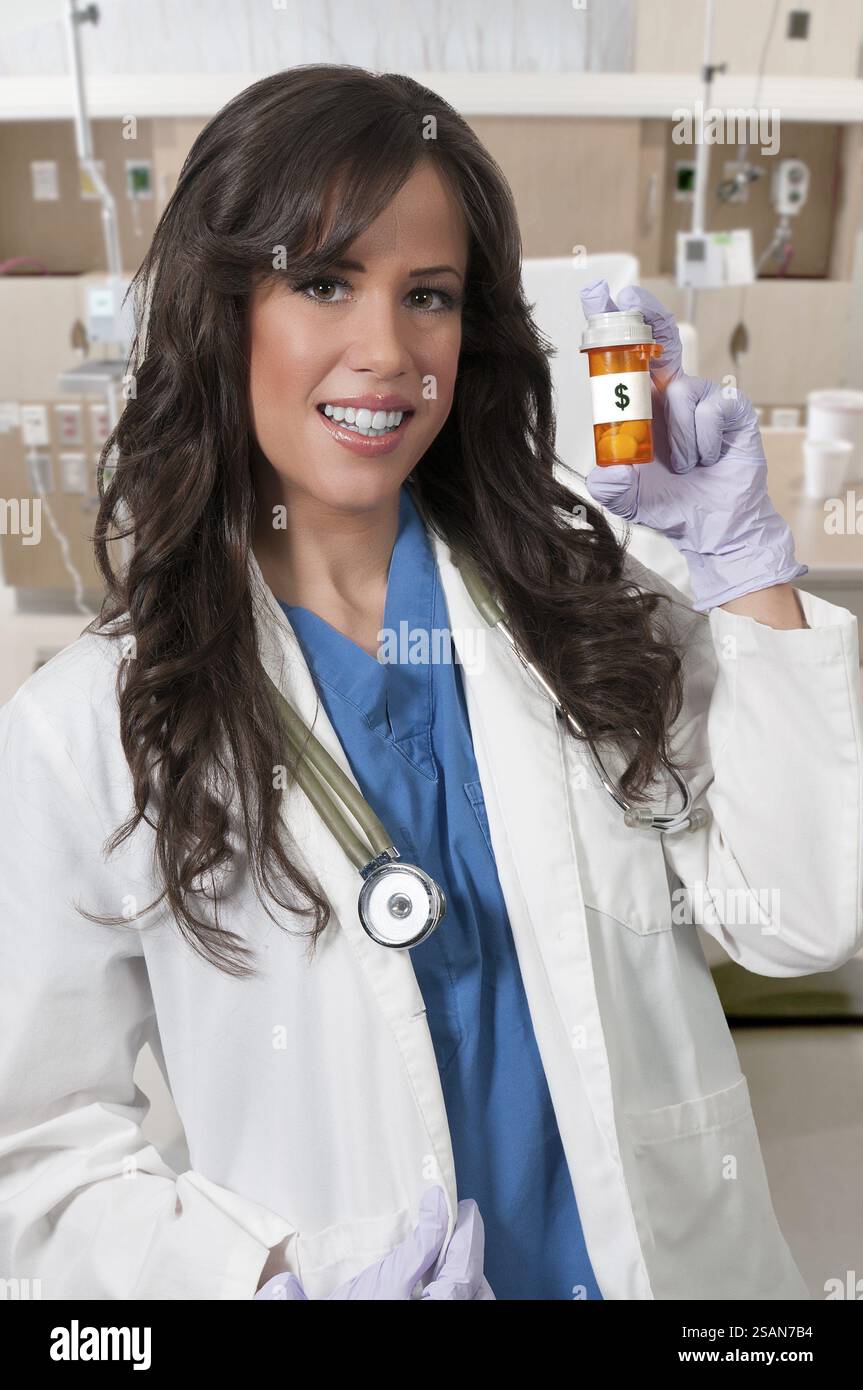 Beautiful young female doctor on her rounds holding a pill bottle of ...