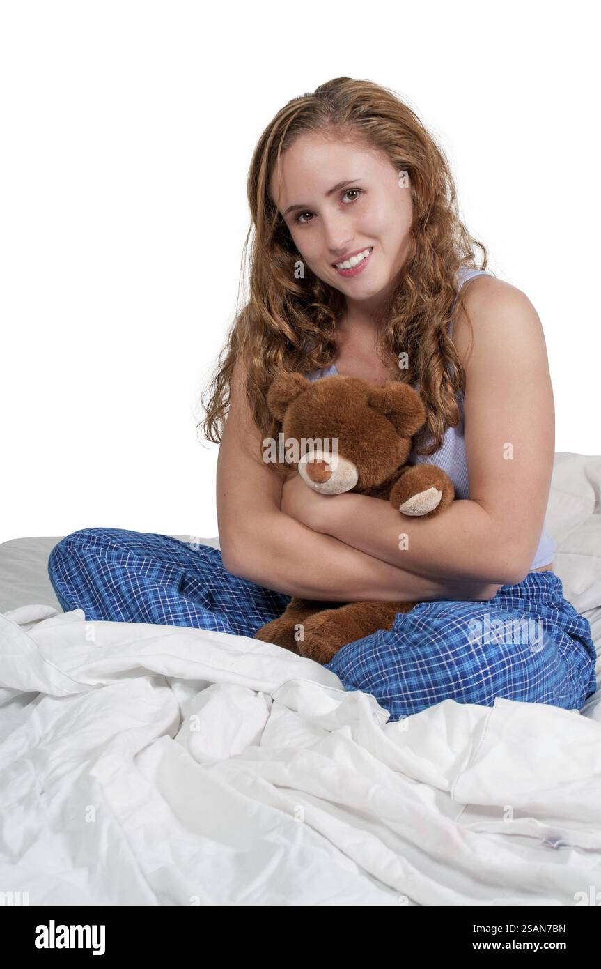 Beautiful young woman in bed at bedtime with a stuffed bear Stock Photo ...