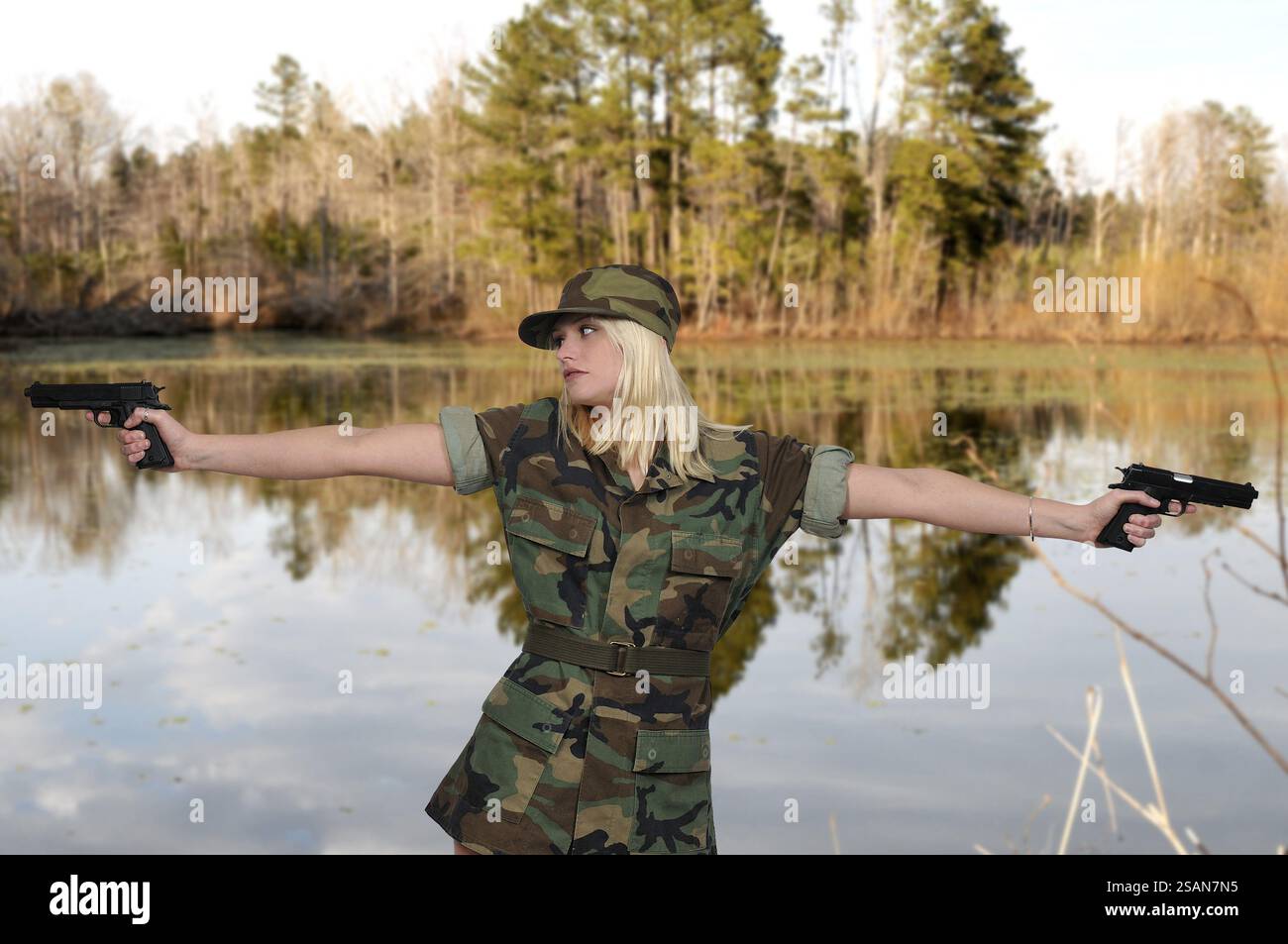 Gun toting beautiful young woman soldier with pistols Stock Photo - Alamy