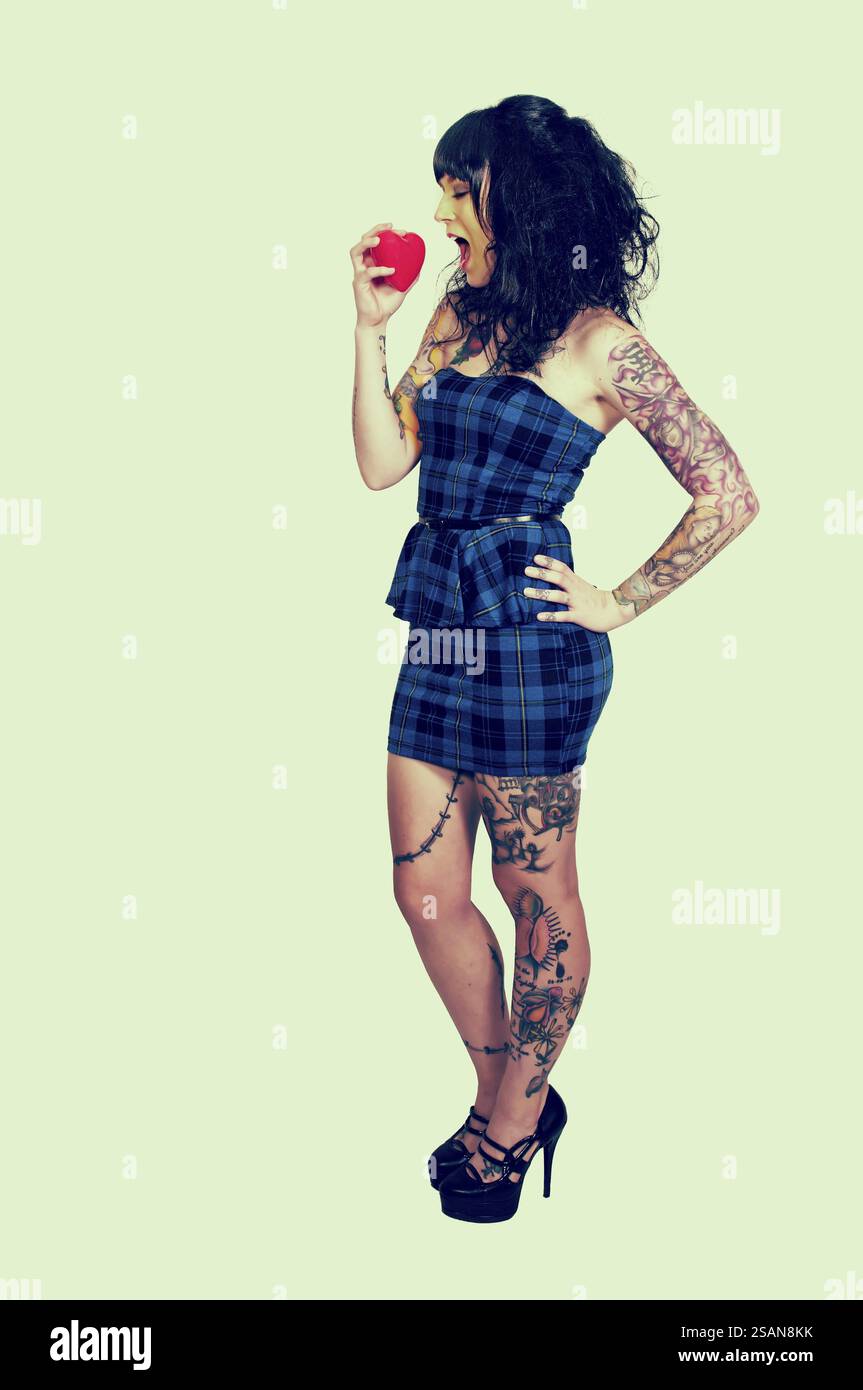 Beautiful young woman eating a Valentines Day heart Stock Photo - Alamy