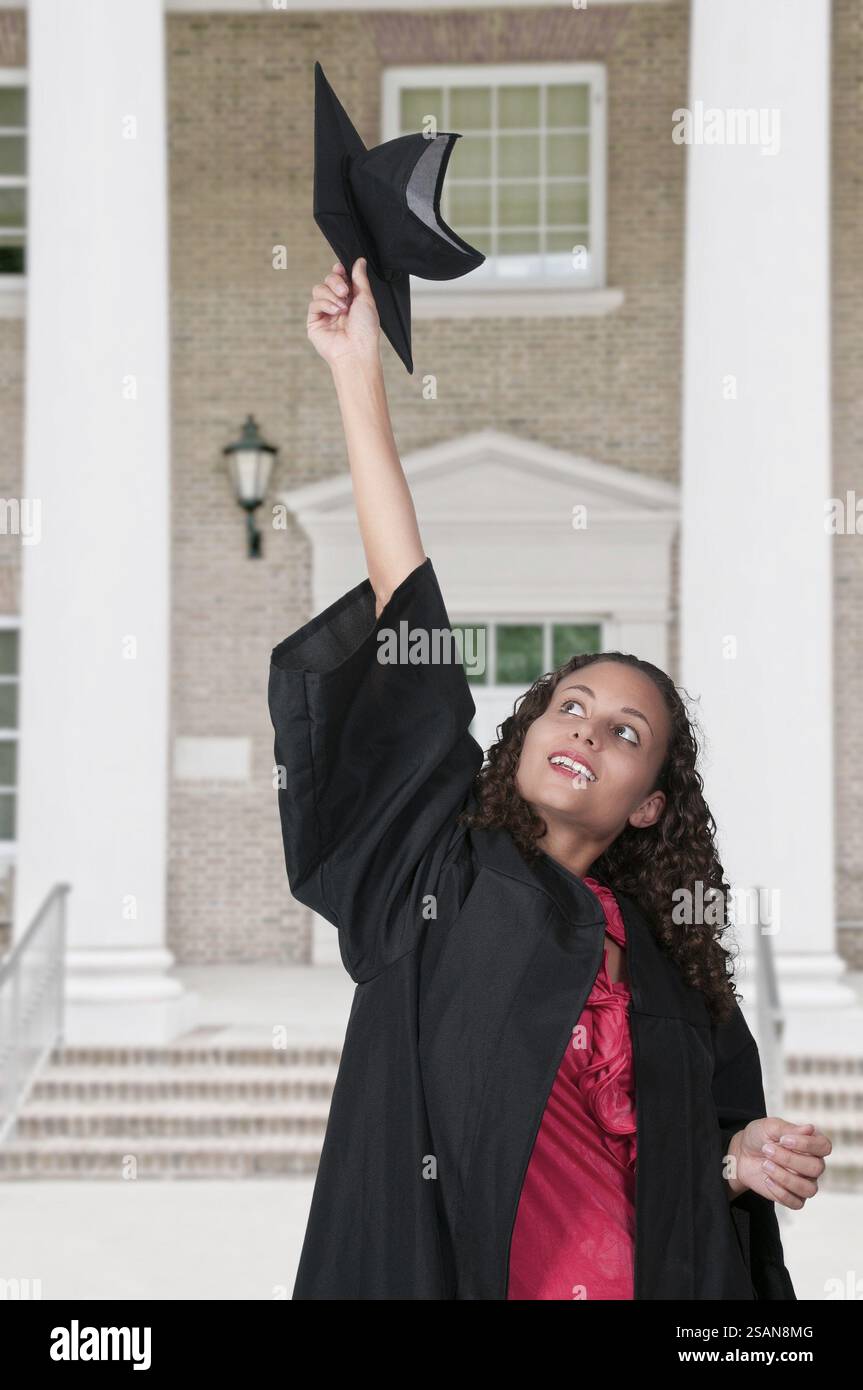 Young woman in her graduation robes throwing her cap Stock Photo - Alamy