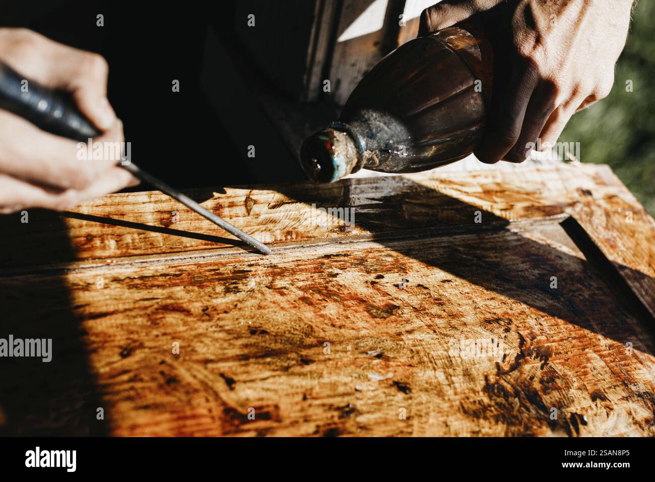 Hands applying finish to wood with tools in sunlight Stock Photo - Alamy