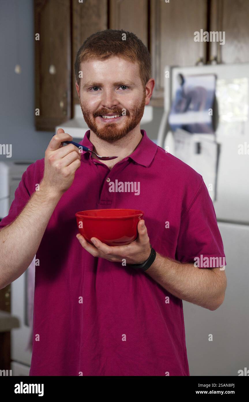 Handsome man eating food from a bowl Stock Photo - Alamy