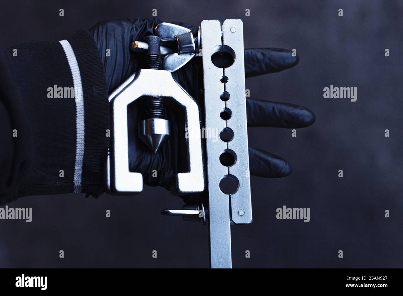 Minimalist image of a hand gripping a metal tool, focusing on precision ...
